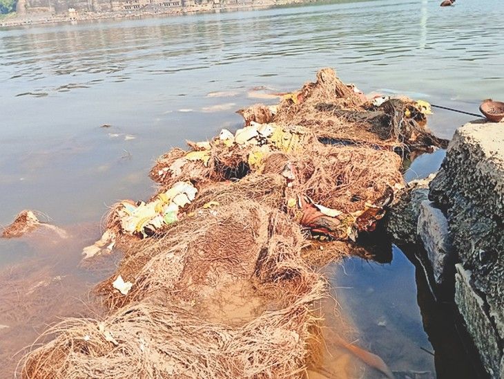 Devotees are bathing among half-dissolved idols on the banks of Narmada ...