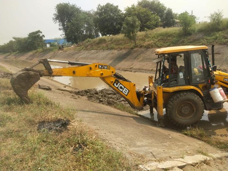 The canal is being cleaned with JCB, Poklane machine and laborers ...
