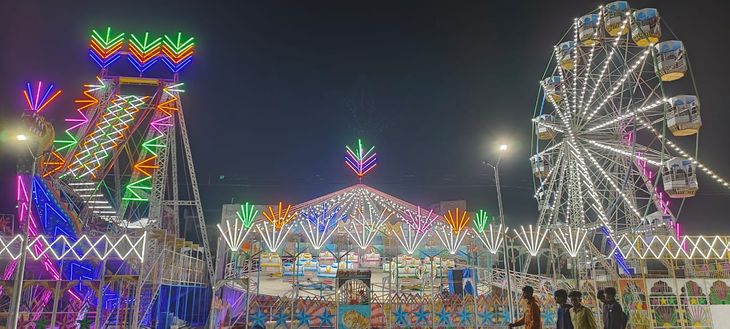 Anand Mela illuminated with colorful lights, tower and dragon swing ...