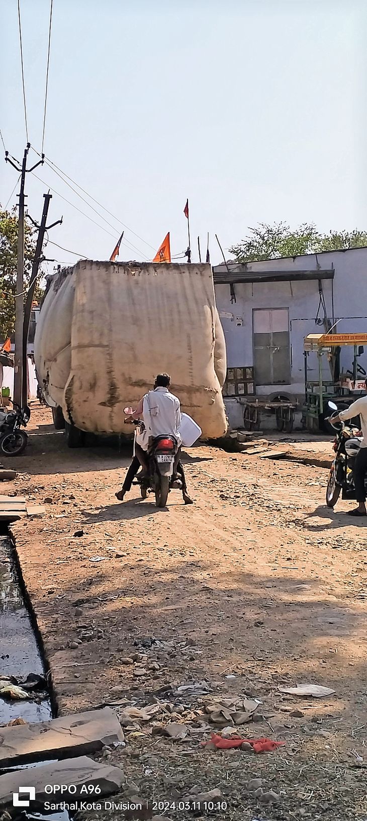 Overloaded tractor-trolleys carrying straw are running in populated ...