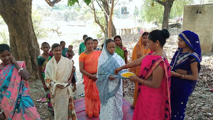 Invitation to vote given by giving turmeric colored rice