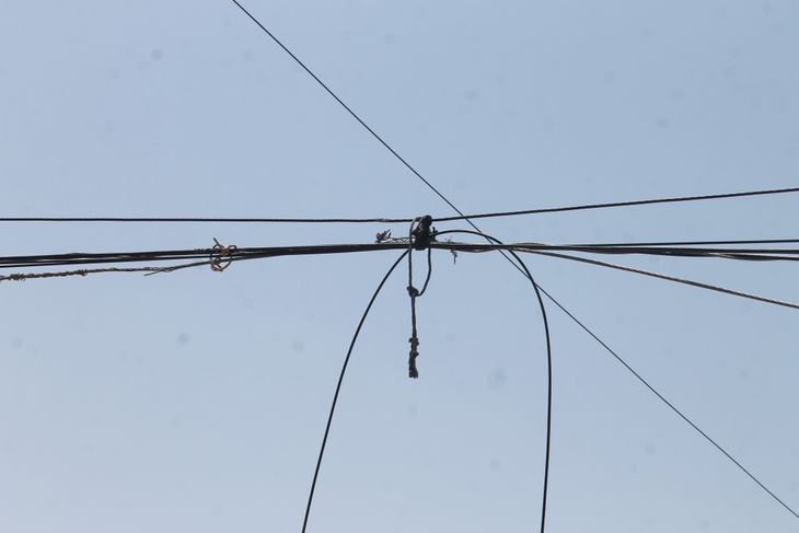 Transformers surrounded by bushes and dangling electric wires are ...