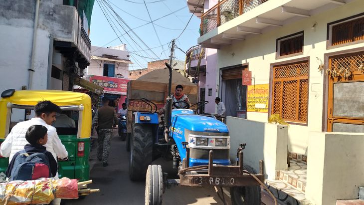Overloaded tractor trolleys filled with sand are running in the streets ...