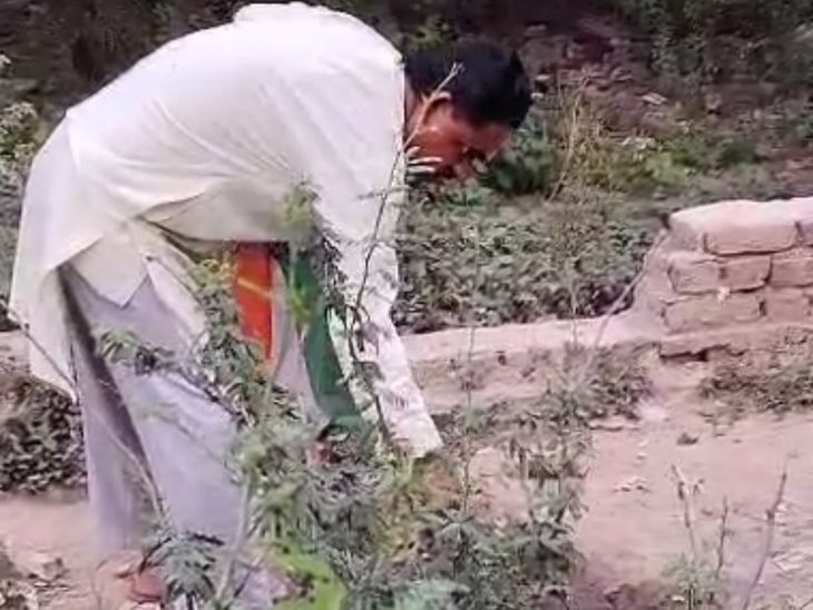 The youth cleaned the drain using the pole of the national flag