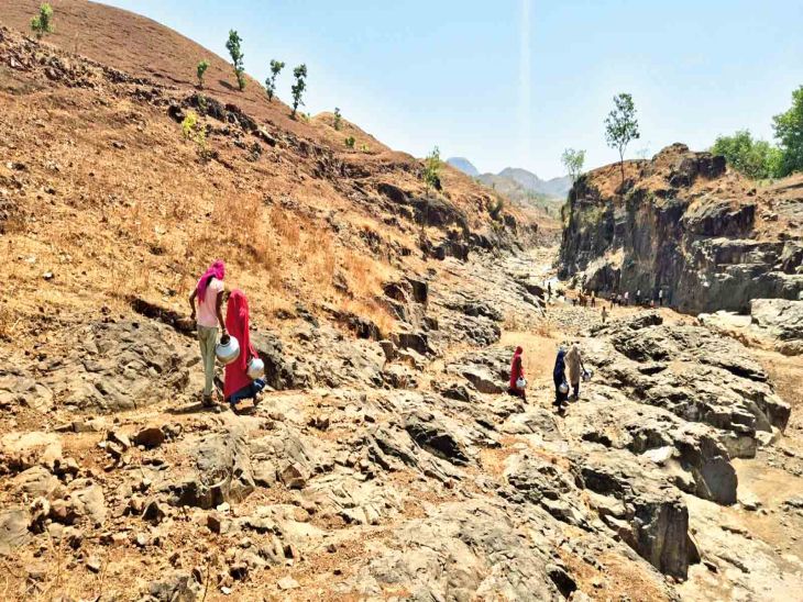 Villagers are drinking water by digging a hole in the Jharkal river on ...