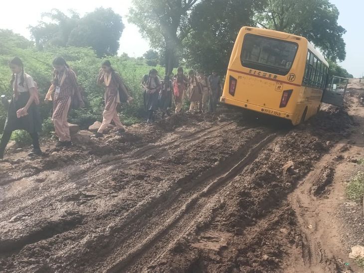 The school bus stuck in the mud was pulled out with the help of a tractor