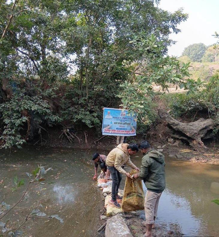 A temporary mud and stone dam is built on the Dabar River.