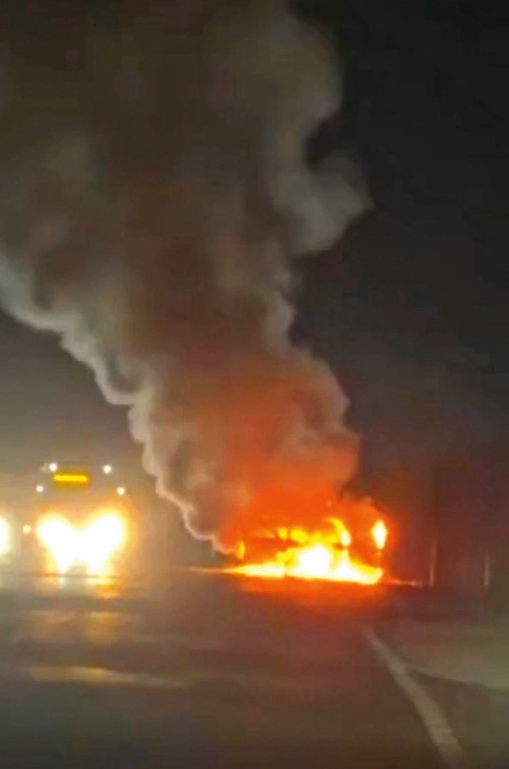 A moving car suddenly caught fire, passengers jumped out and ran away.