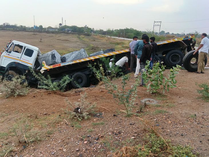 A trailer loaded with granite blocks skidded off the road, and the ...