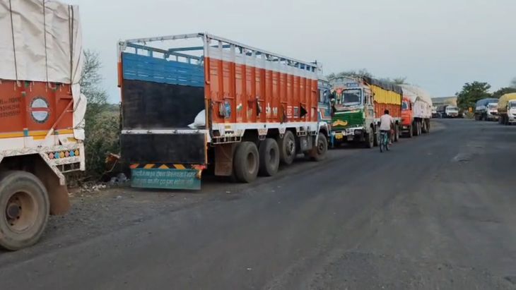 Trucks loaded with wheat are parked on the road, drivers have been ...