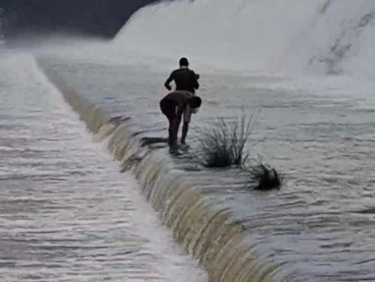 Two youths seen fishing amid rushing water on Damanganga river causeway ...