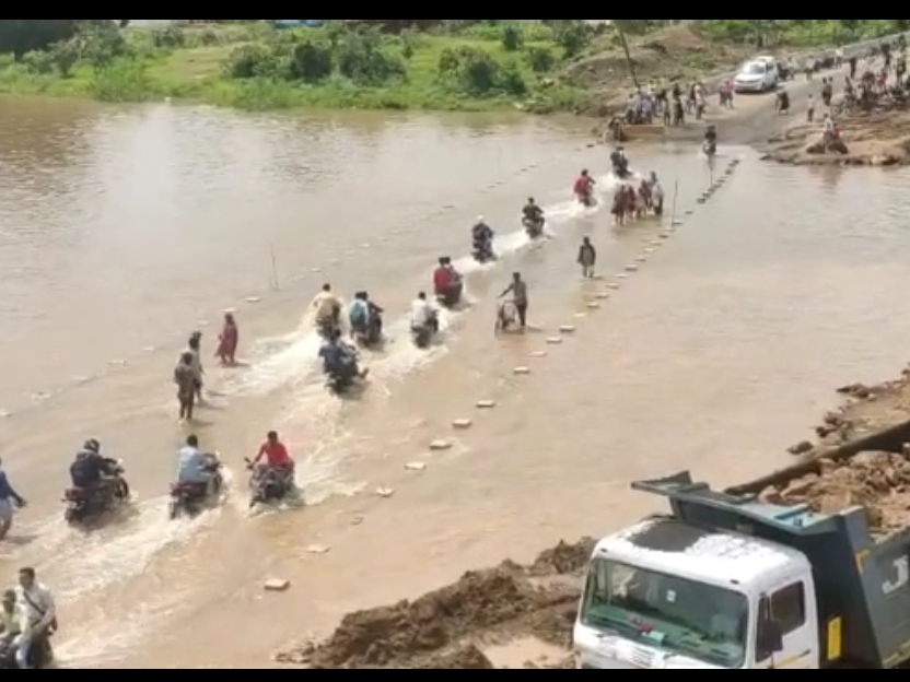 People crossing the Sukhtwa bridge submerged in water, then carried ...