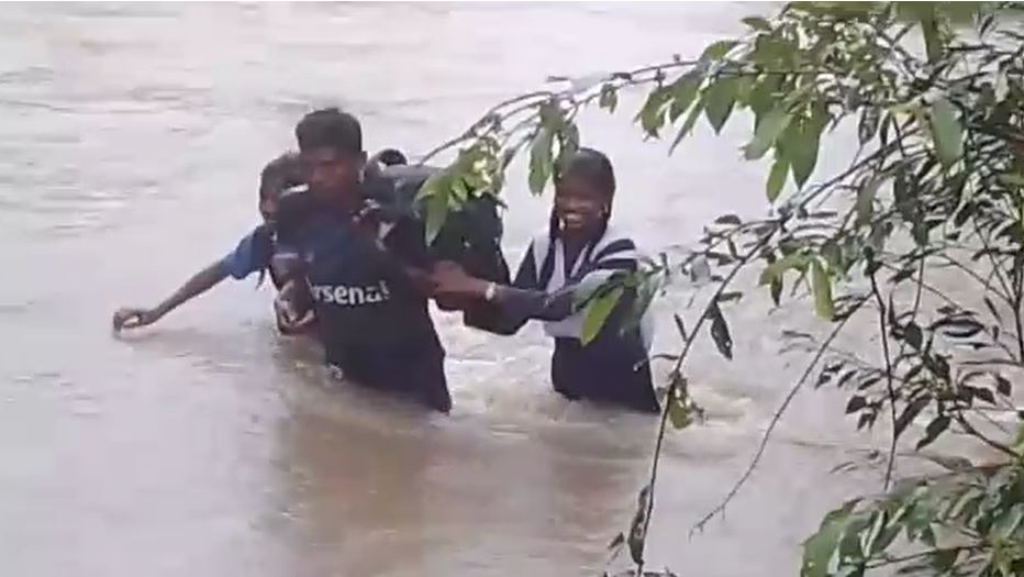 Students passing through a overflowing drain amid rain in Balaghat ...