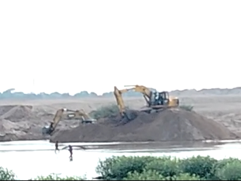 Poklen machines are extracting sand from the water stream of Ken river ...