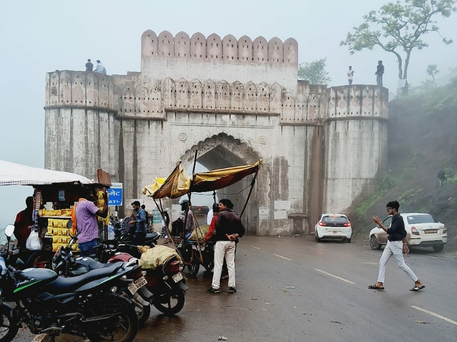 Jam Gate surrounded by tourists covered with a sheet of greenery amidst ...