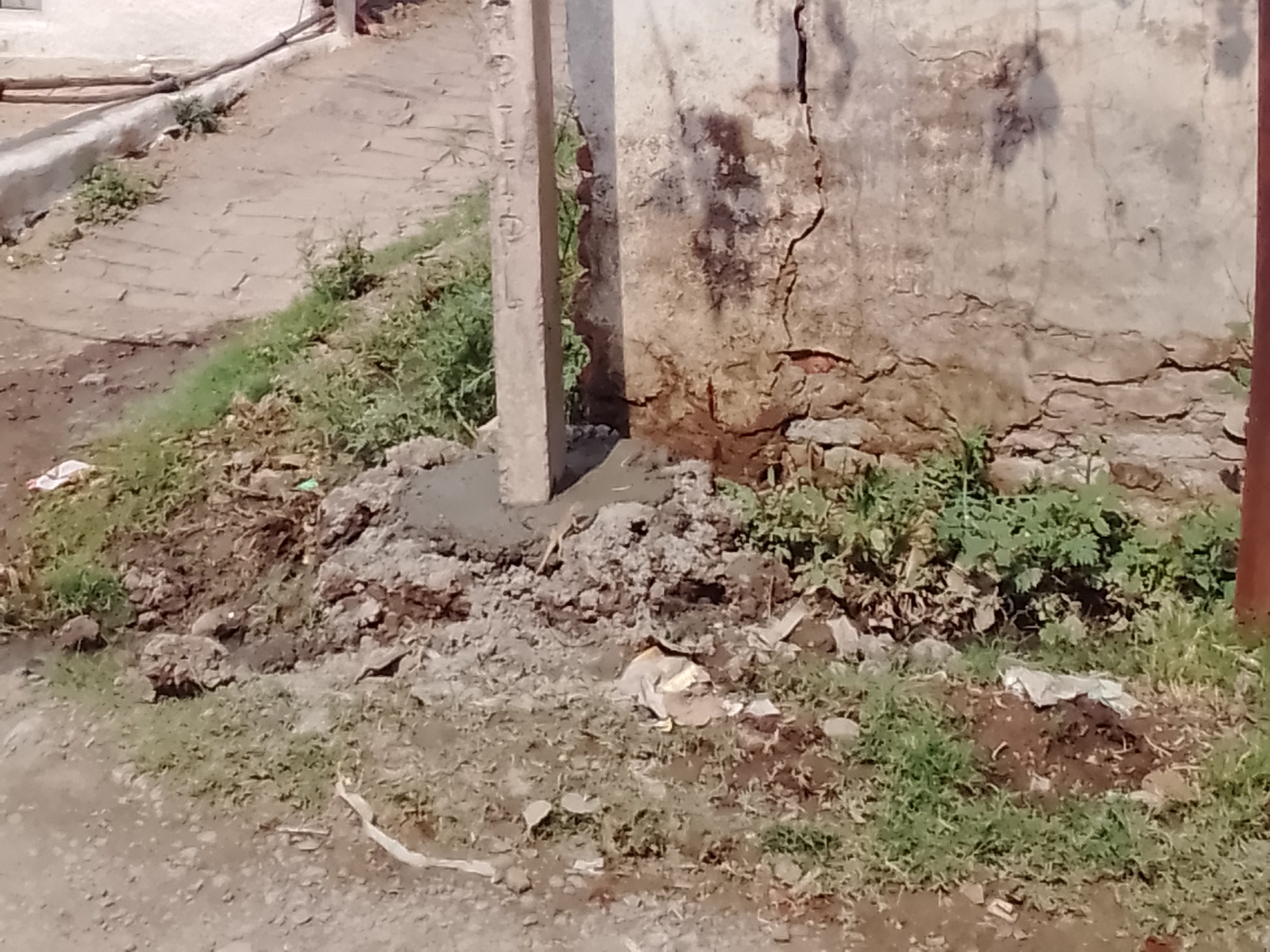 Electricity pole buried in the drain, dirt flowing on the road ...
