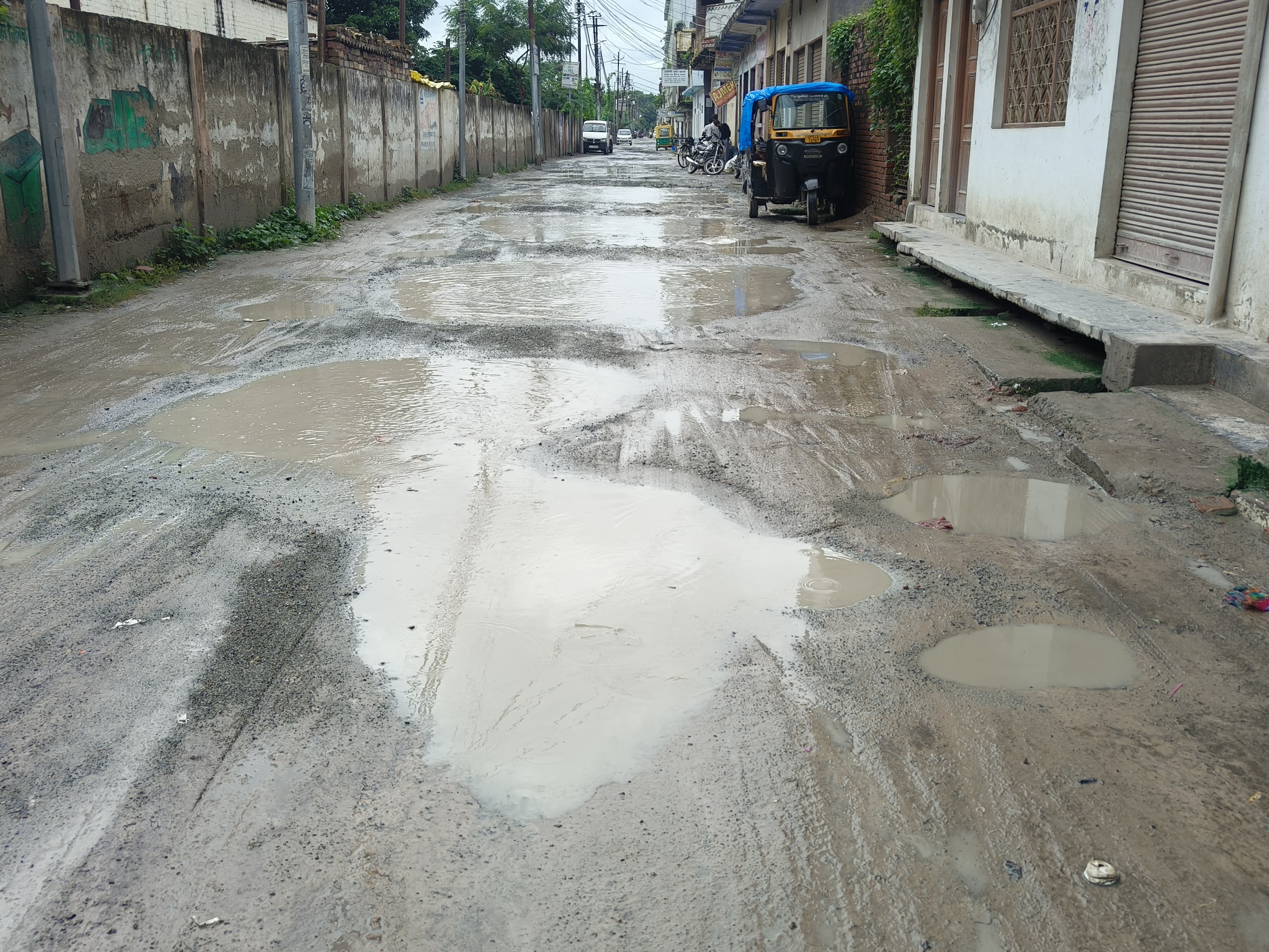 Water filled in the potholes on Shahidi Road of Mau