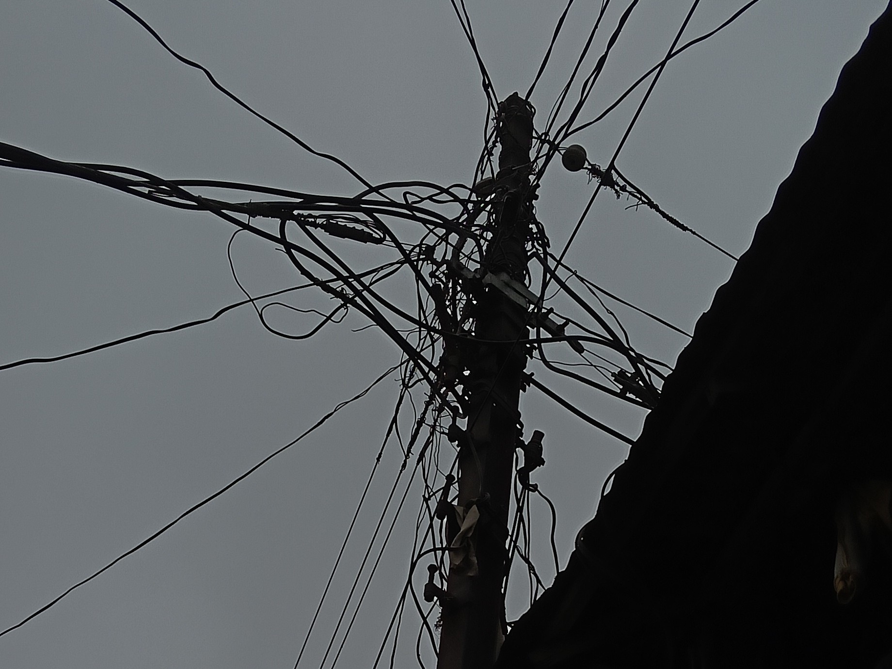 A spider web of wires on an electric pole in Sohanpur Market