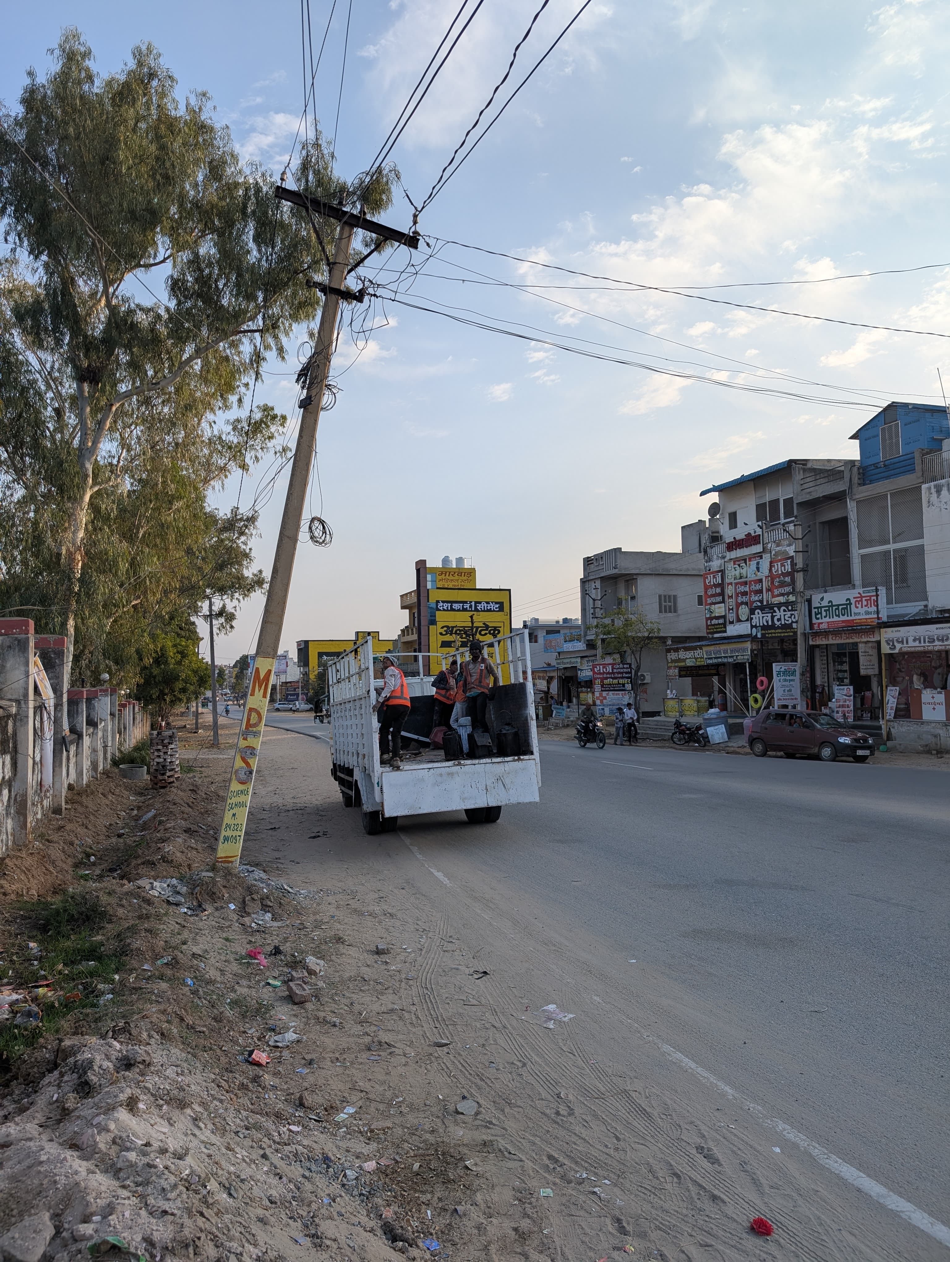 A tilted power pole on the state highway in Mukundgarh raises the ...
