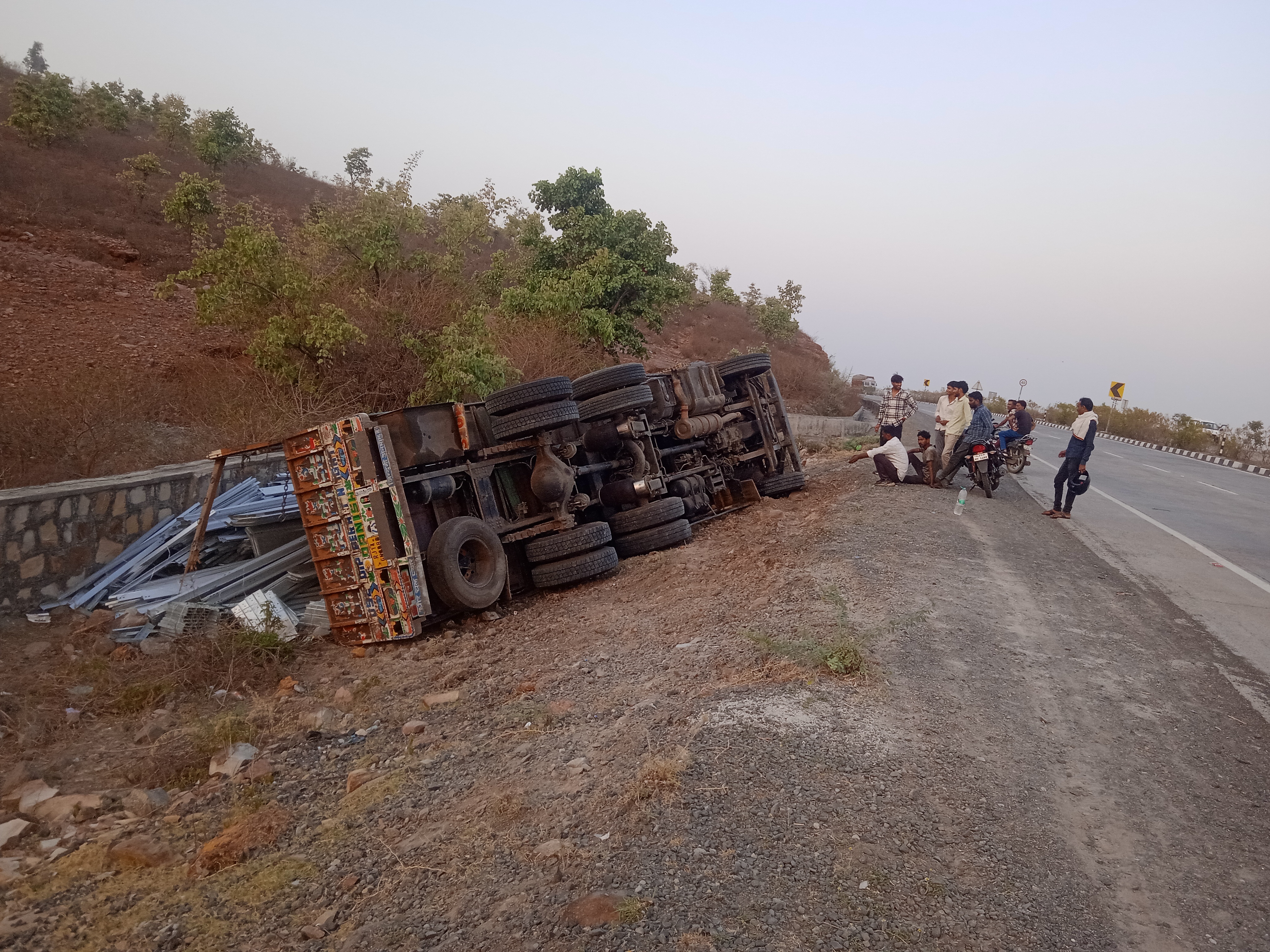 A truck loaded with iron rods overturned on NH-52, driver injured