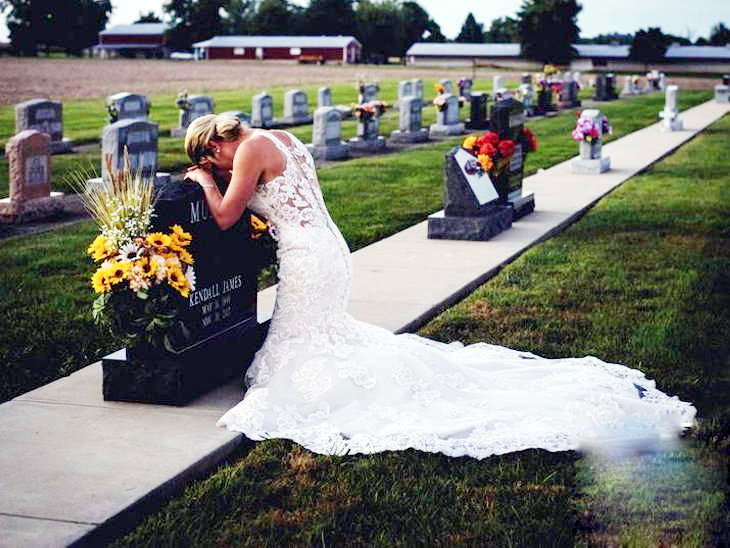 Grieving bride in wedding dress sobs on grave of dead fiance ...