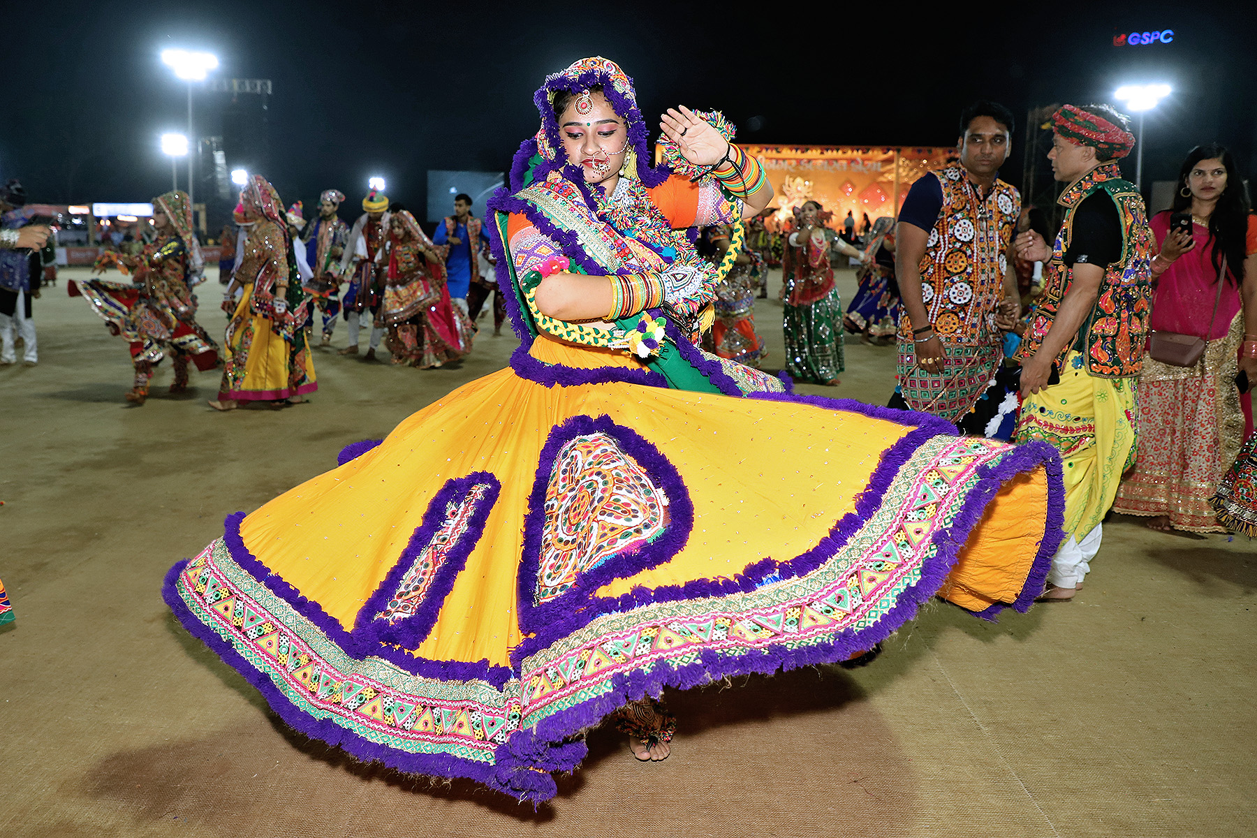A Gujarati walking around in a red-green chaniyacholi and a white kadia ...
