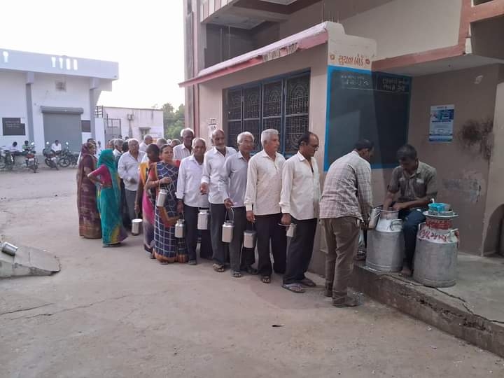There was a queue to take milk in front of the village milk dairy | ગામની દૂધ ડેરી આગળ દૂધ લેવા ...